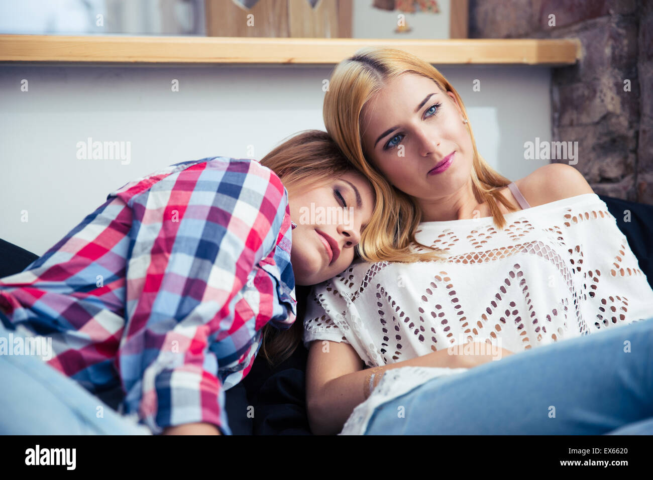 Two young women resting on the sofa at home Stock Photo - Alamy