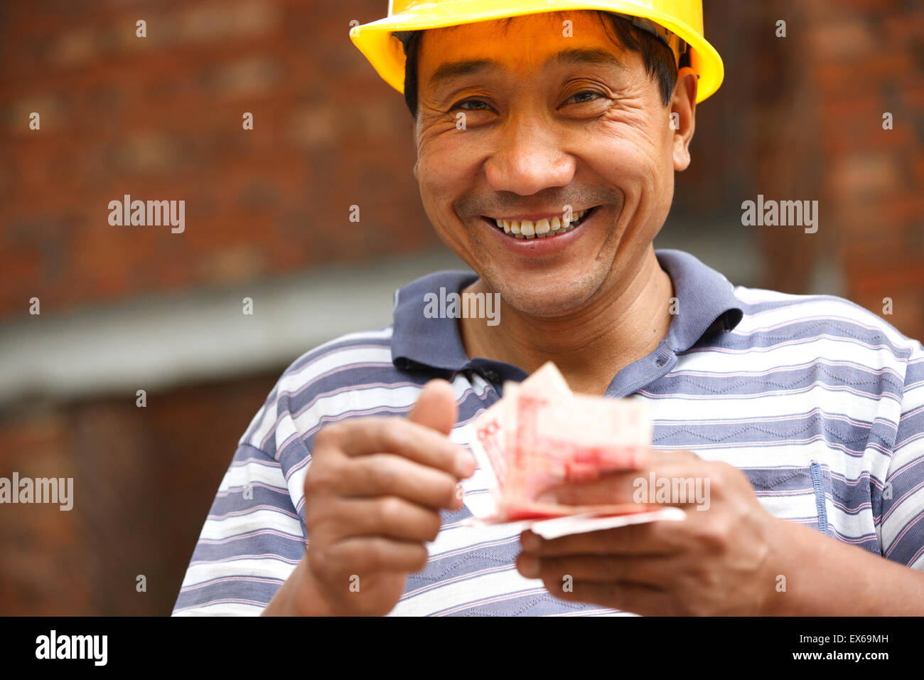 Construction worker counting paper money Stock Photo - Alamy