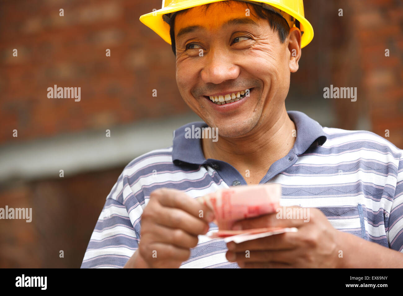 Construction worker counting paper money Stock Photo - Alamy