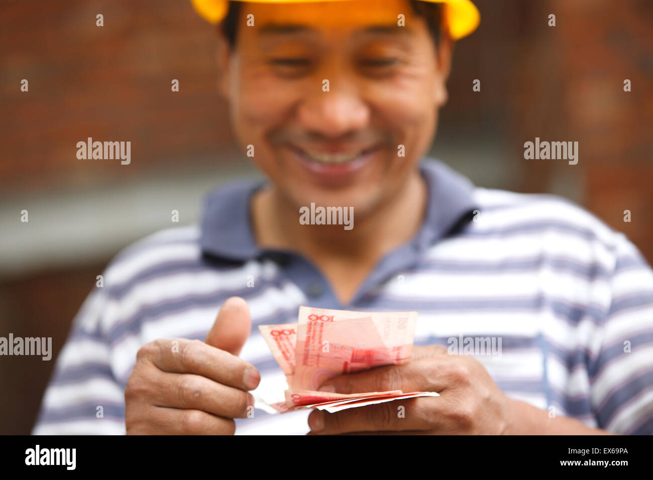 Construction worker counting paper money Stock Photo - Alamy