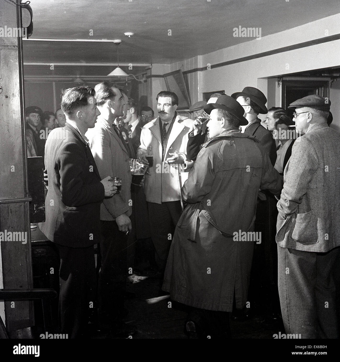 historical, 1950s, group of men having a discussion over a drink in a ...