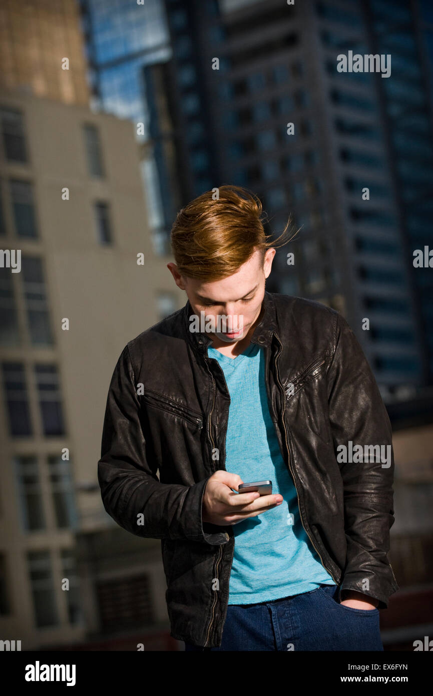 boy checking his phone in the city Stock Photo - Alamy