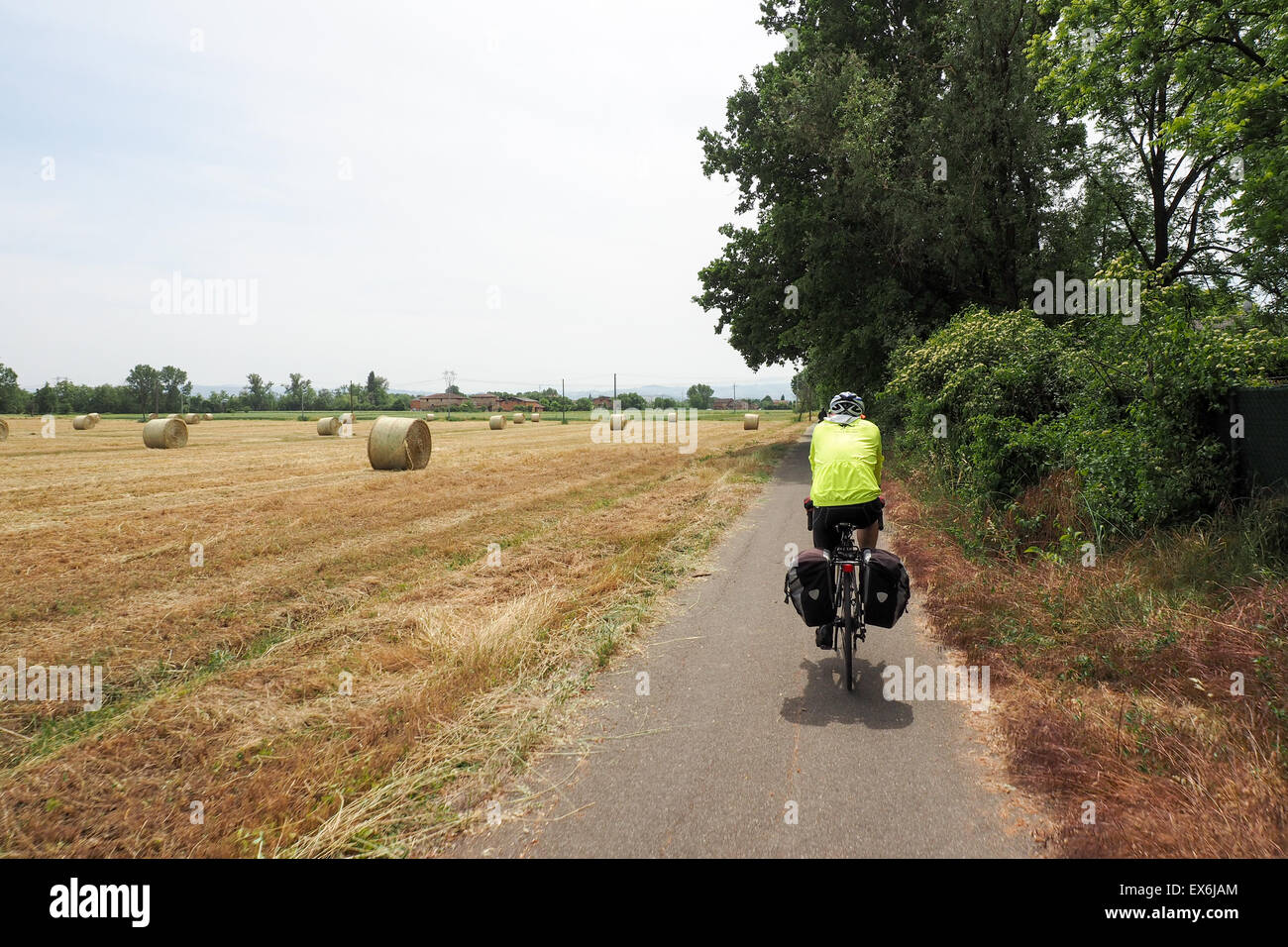Touring cyclist cycling on a bike path in the countryside alongside ...