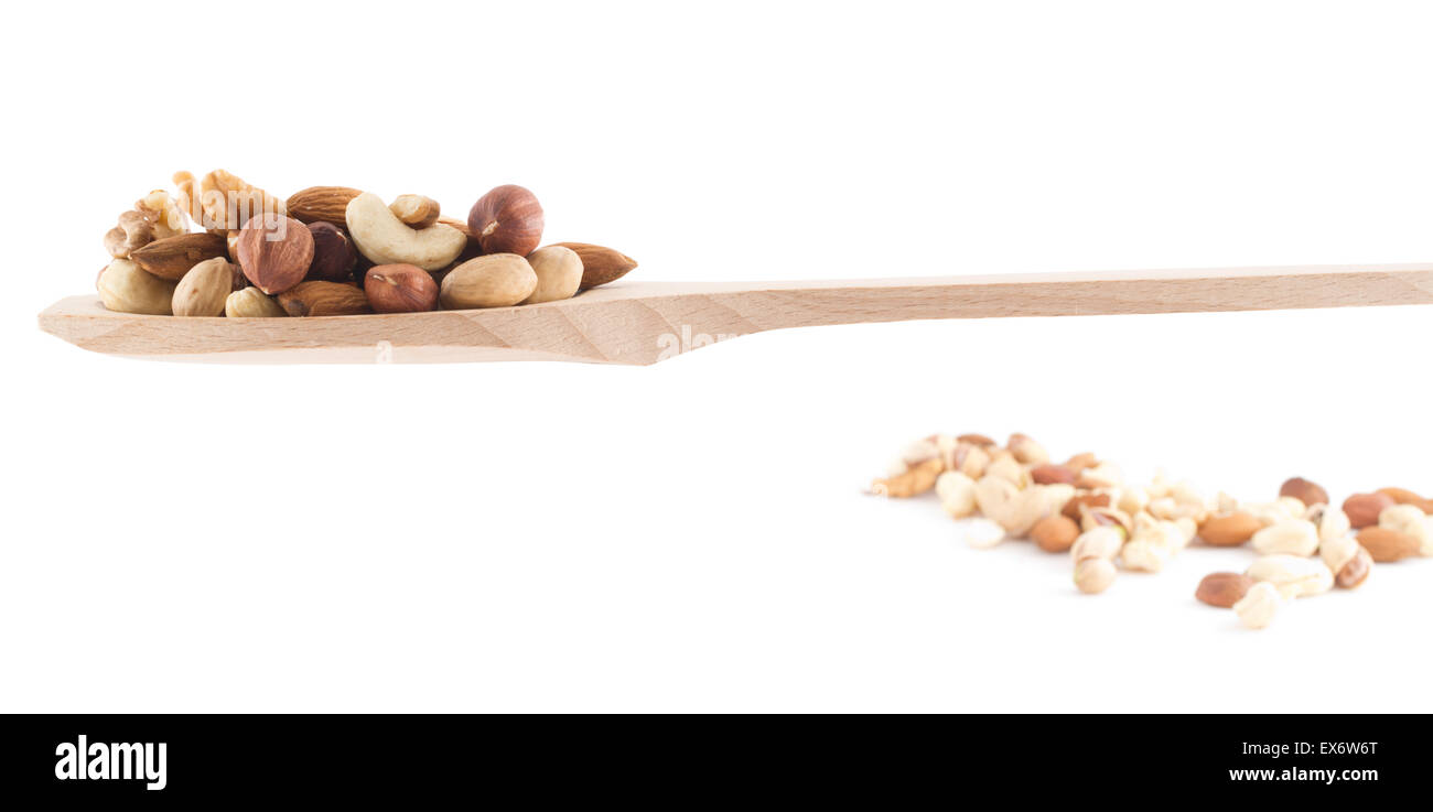 Spoon full of nuts mix over white Stock Photo - Alamy