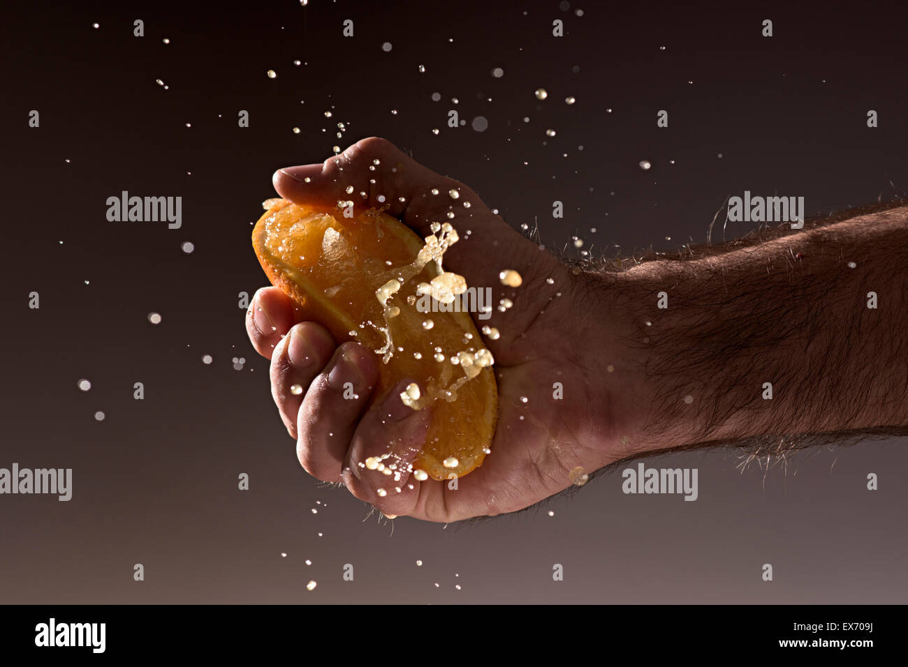 Hand squeezing orange hi-res stock photography and images - Alamy