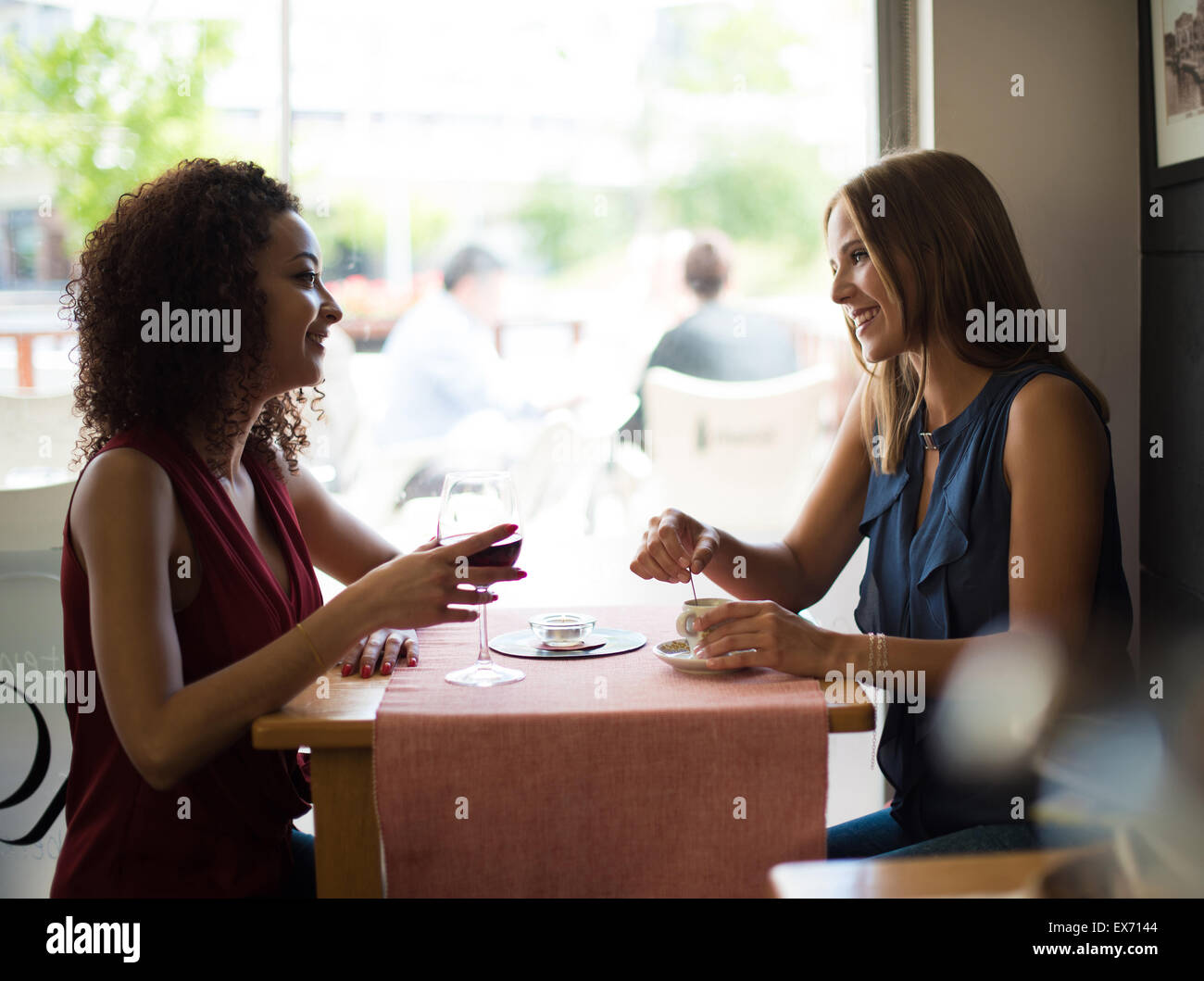 Pretty women talking and having fun inside coffee shop Stock Photo - Alamy