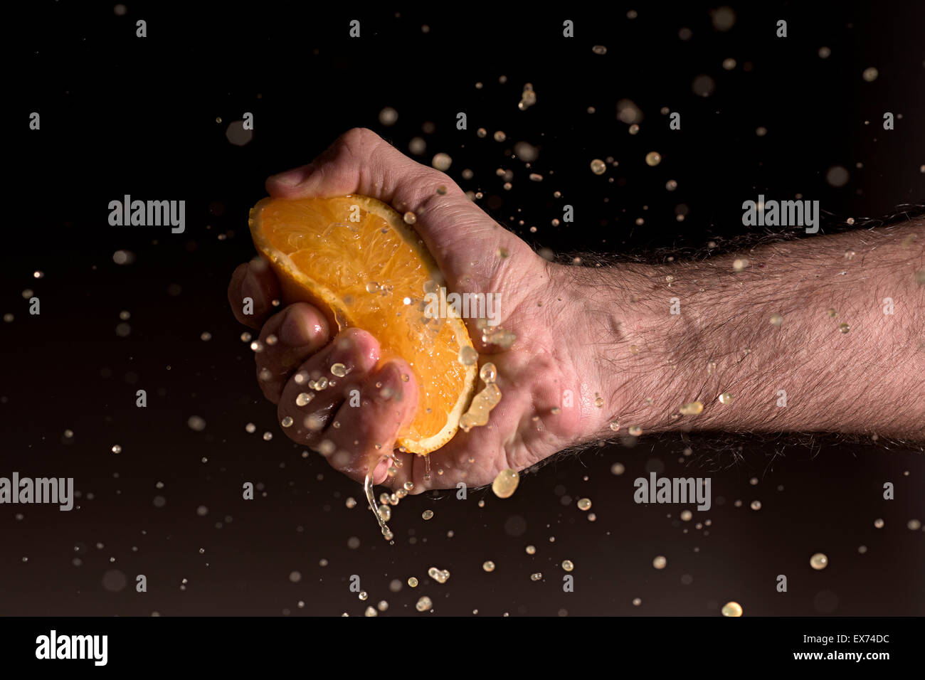 Male hand squeezing an orange Stock Photo - Alamy