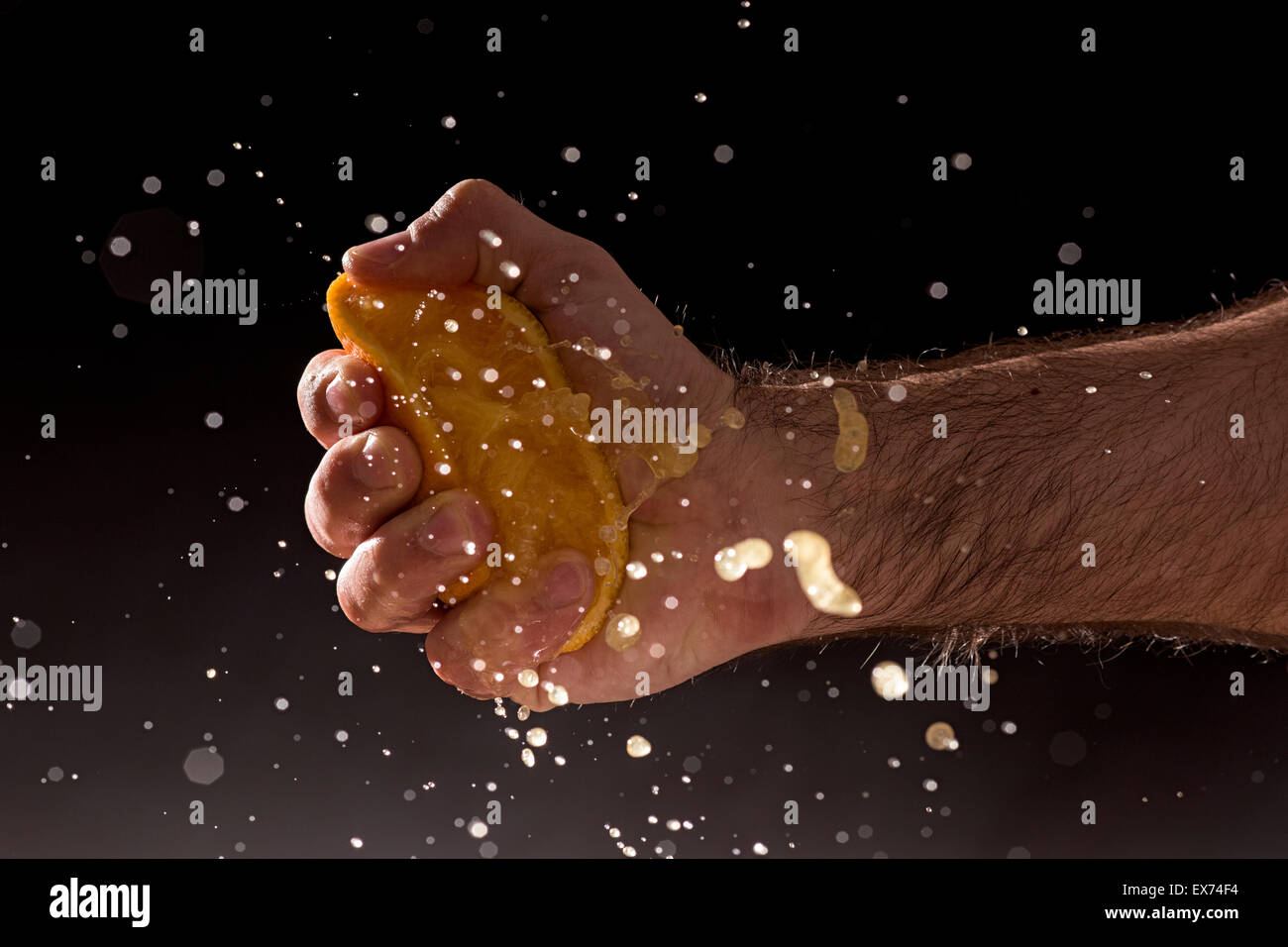 Male hand squeezing an orange Stock Photo - Alamy