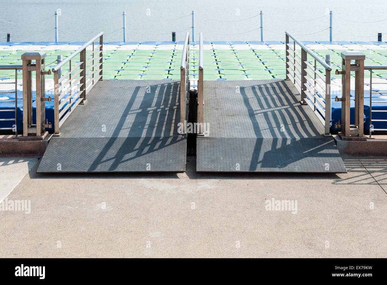 Metal bridge to the colorful pontoon on small lake Stock Photo - Alamy