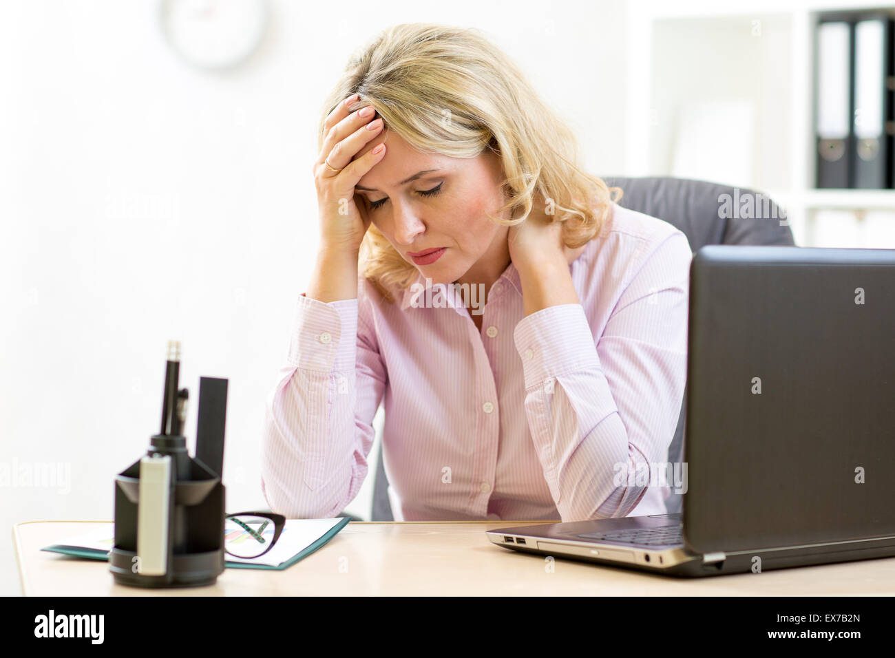 Tired middle-aged businesswoman in her office looking down Stock Photo ...