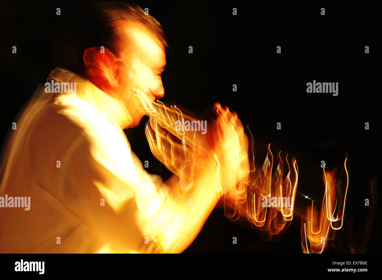 Body motion of a musician playing live on stage and streaks of colours ...