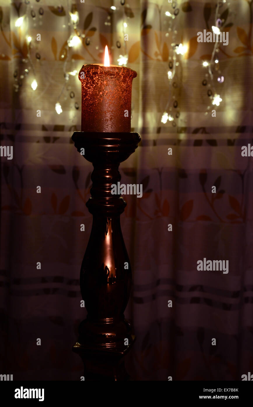 Orange candle over christmas lights Stock Photo - Alamy