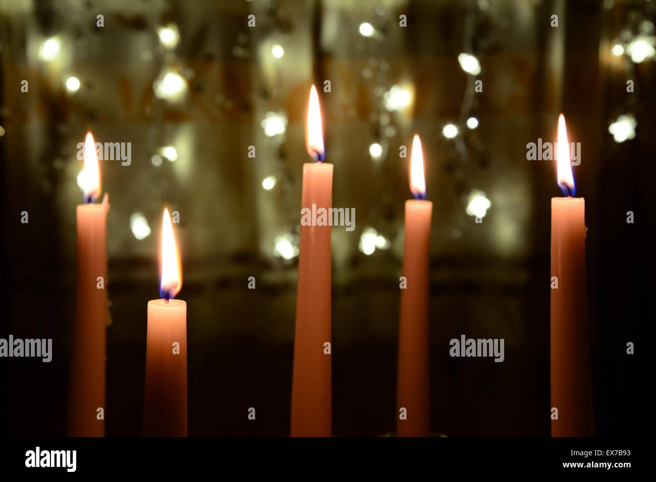 Five white candles over christmas lights Stock Photo - Alamy