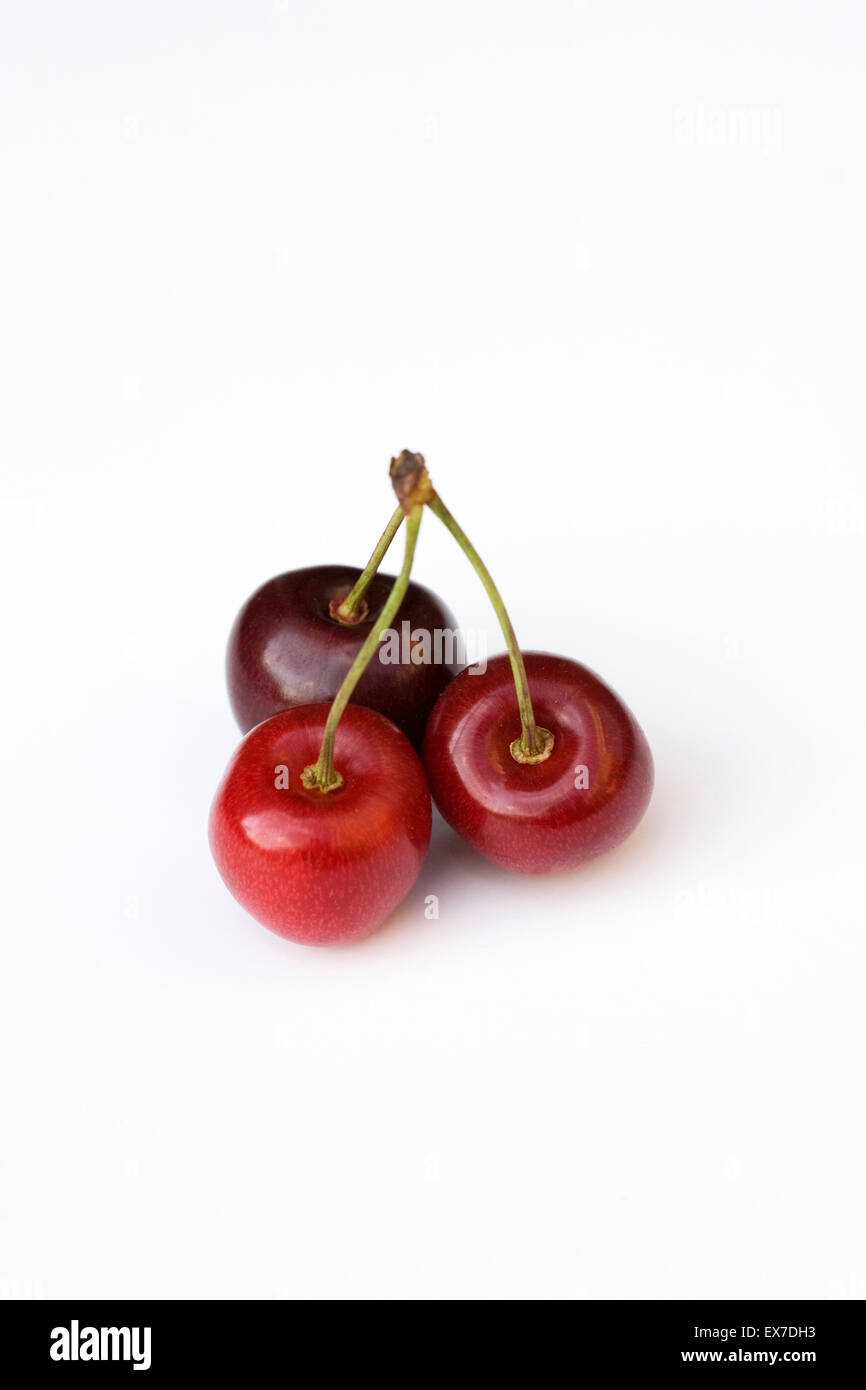 Three cherries on a white background Stock Photo - Alamy