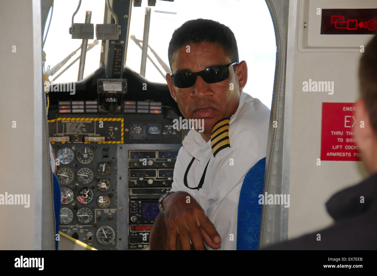 Seychelles Airlines pilot looks out of the cab talking to a passenger ...