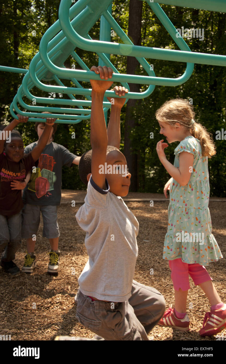 Child playing on a overhead ladder swing in a school playground Stock ...