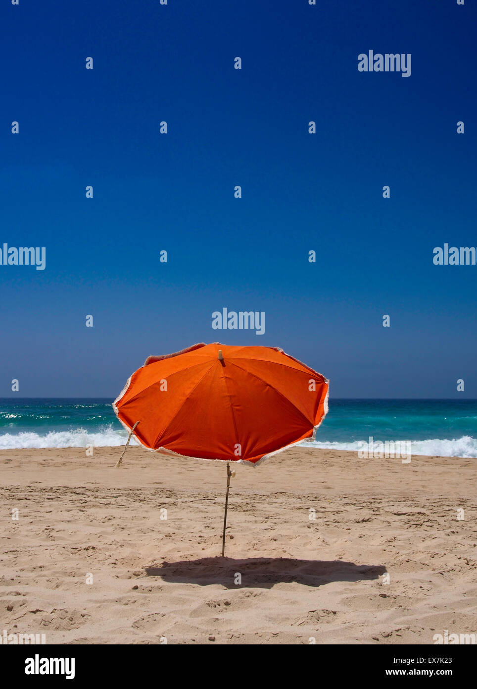 Orange parasol on the beach with blue sky Stock Photo - Alamy