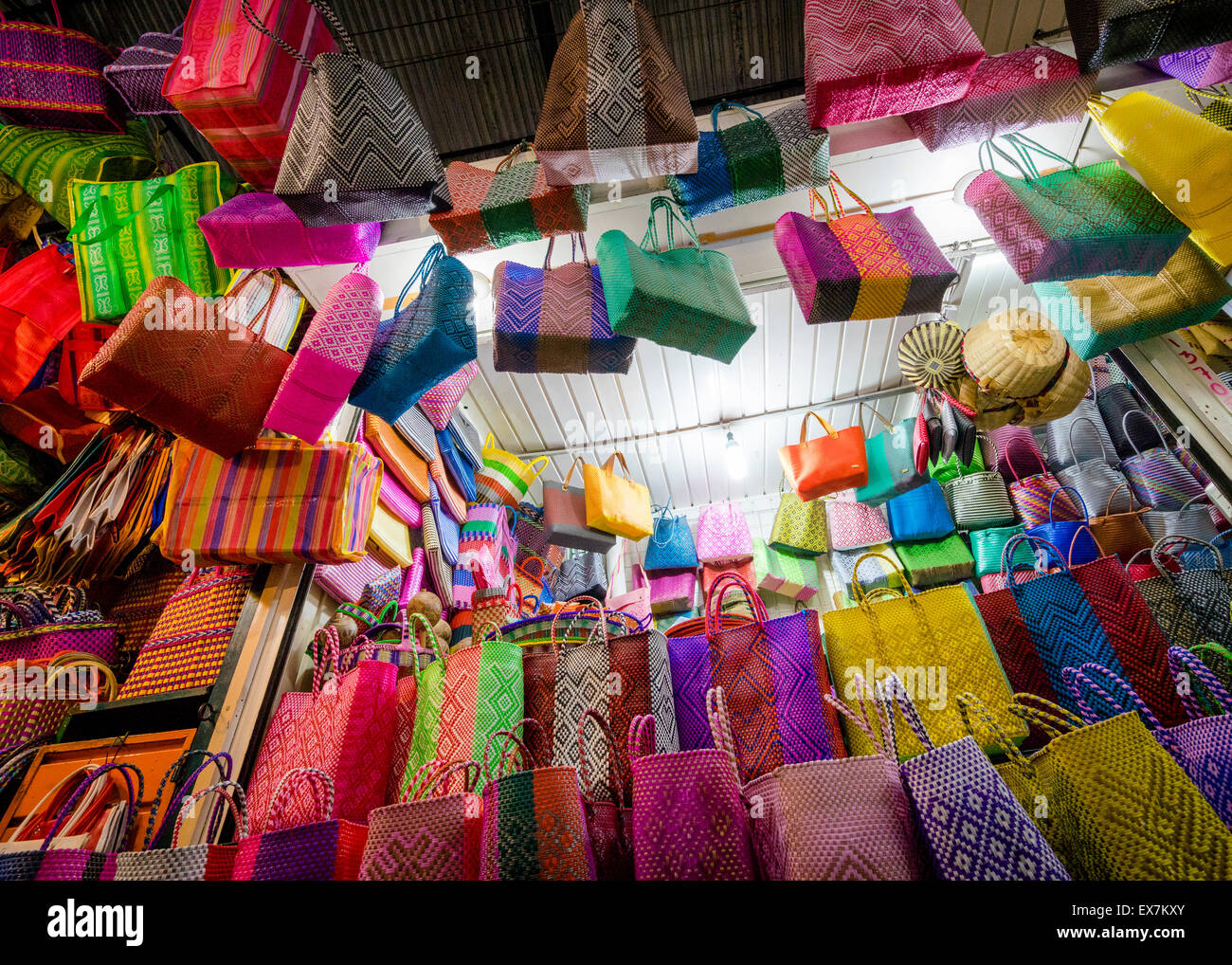 Display of brightly colored woven bags hanging in a stall in Benito ...