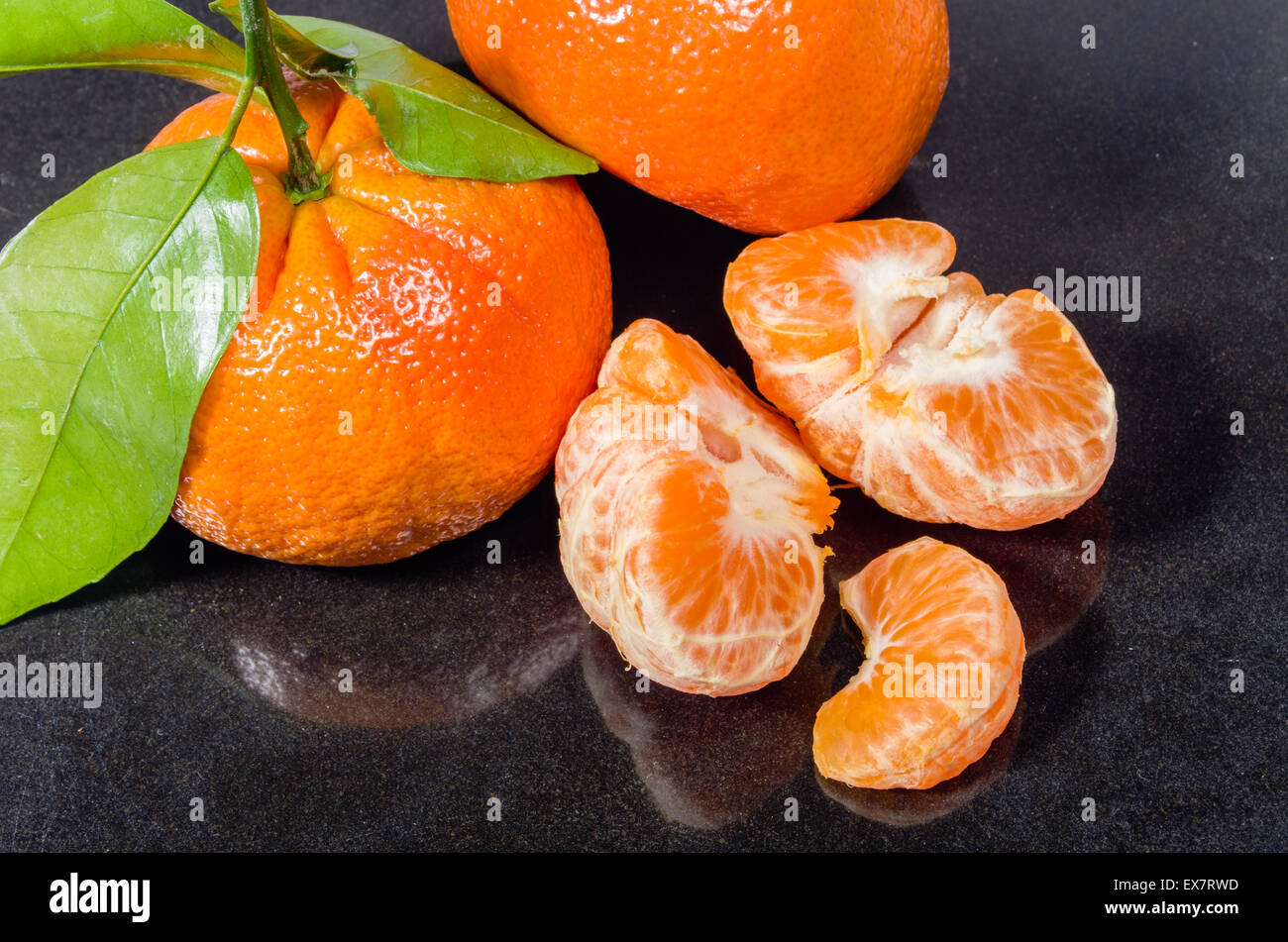 Ripe tangelos with green leaves and fruit sections Stock Photo - Alamy