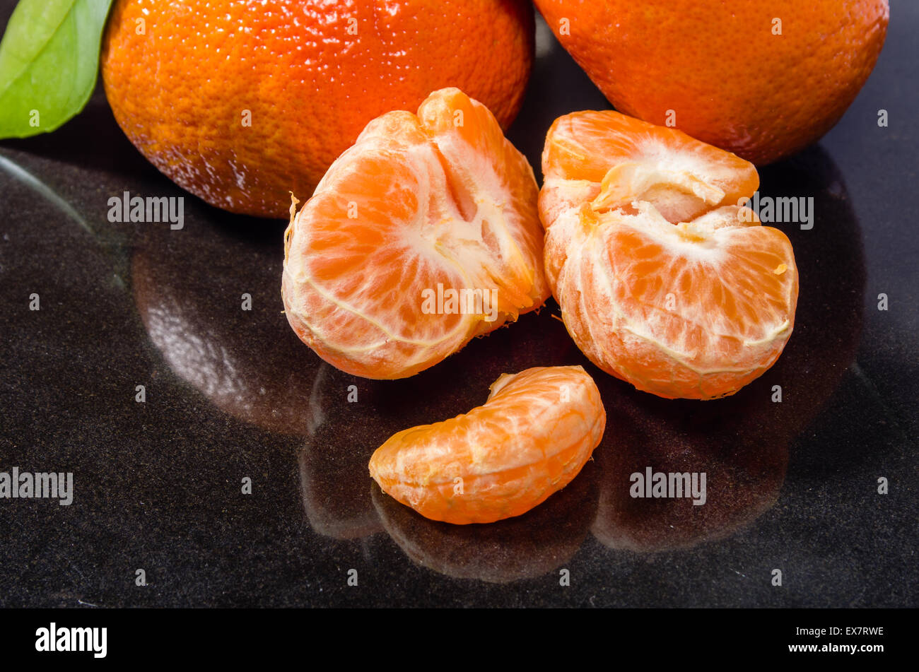 Ripe tangelos with green leaves and fruit sections Stock Photo - Alamy