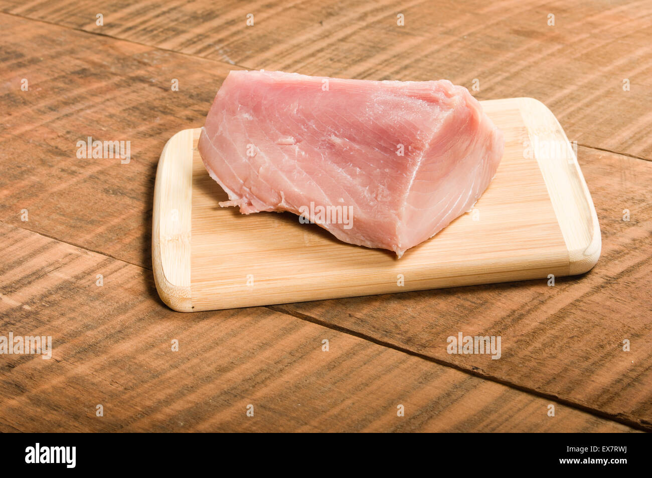 Raw tuna steak on cutting board for preparation Stock Photo - Alamy