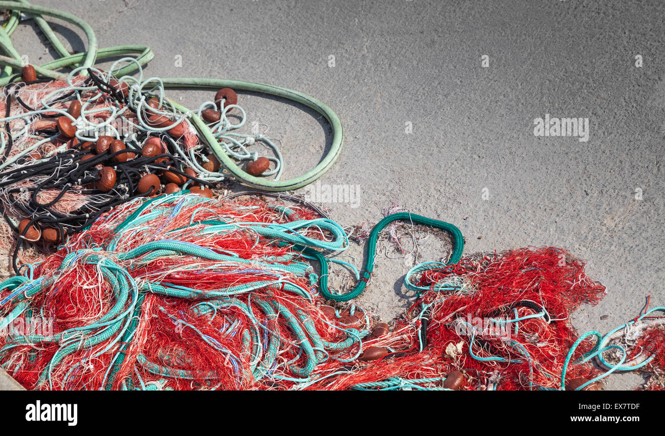 Colorful fishing nets lay on old concrete pier Stock Photo - Alamy