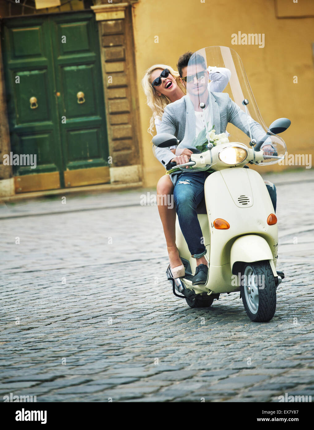 Handsome guy riding a scooter with his girlfriend Stock Photo - Alamy