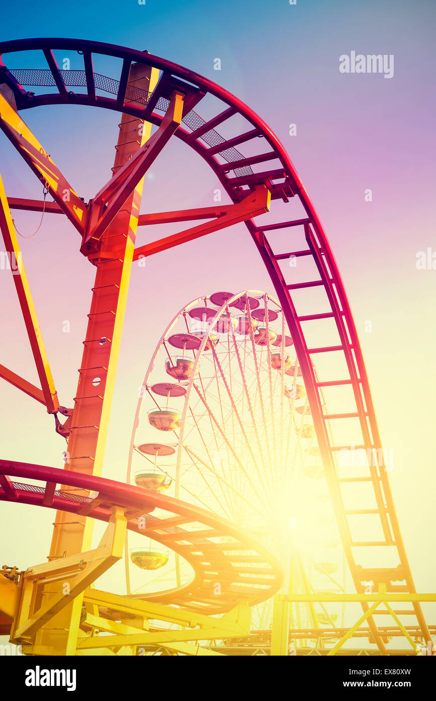 Vintage stylized roller coaster in amusement park at sunset Stock Photo ...