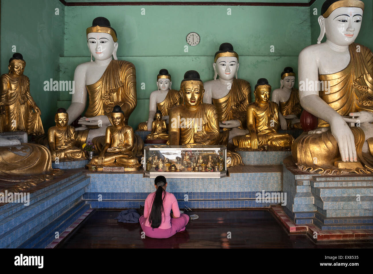 Local woman meditating in front of Buddha statues, Shwedagon Pagoda ...