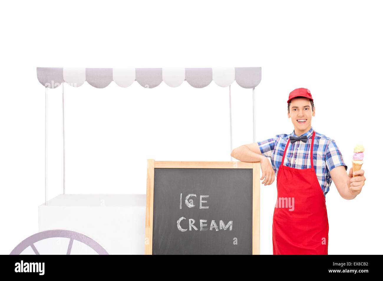 Young male vendor standing by an ice cream stand and holding an ice ...