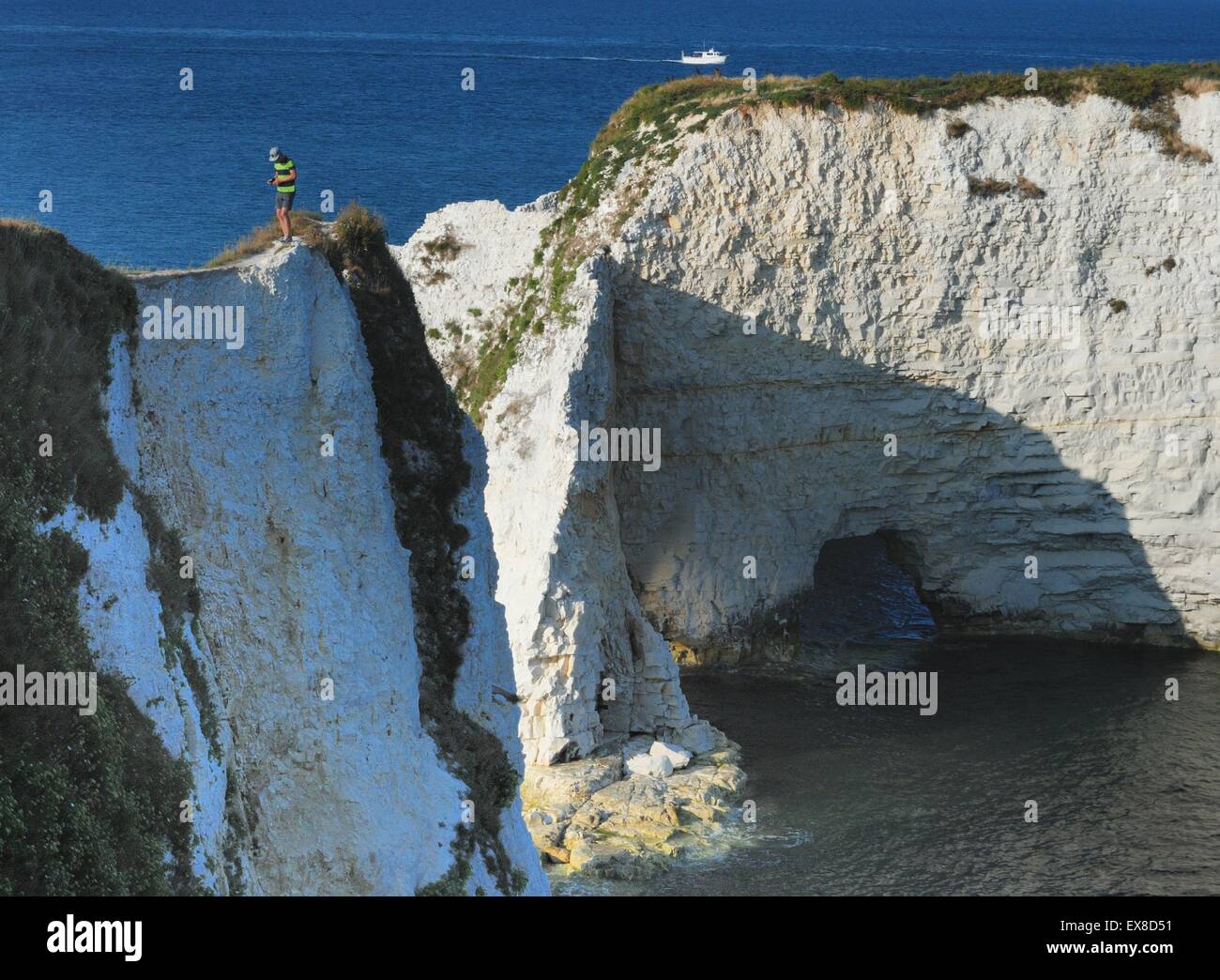 Fearless teenager walking along a narrow ridge path at Old Harry Rocks ...