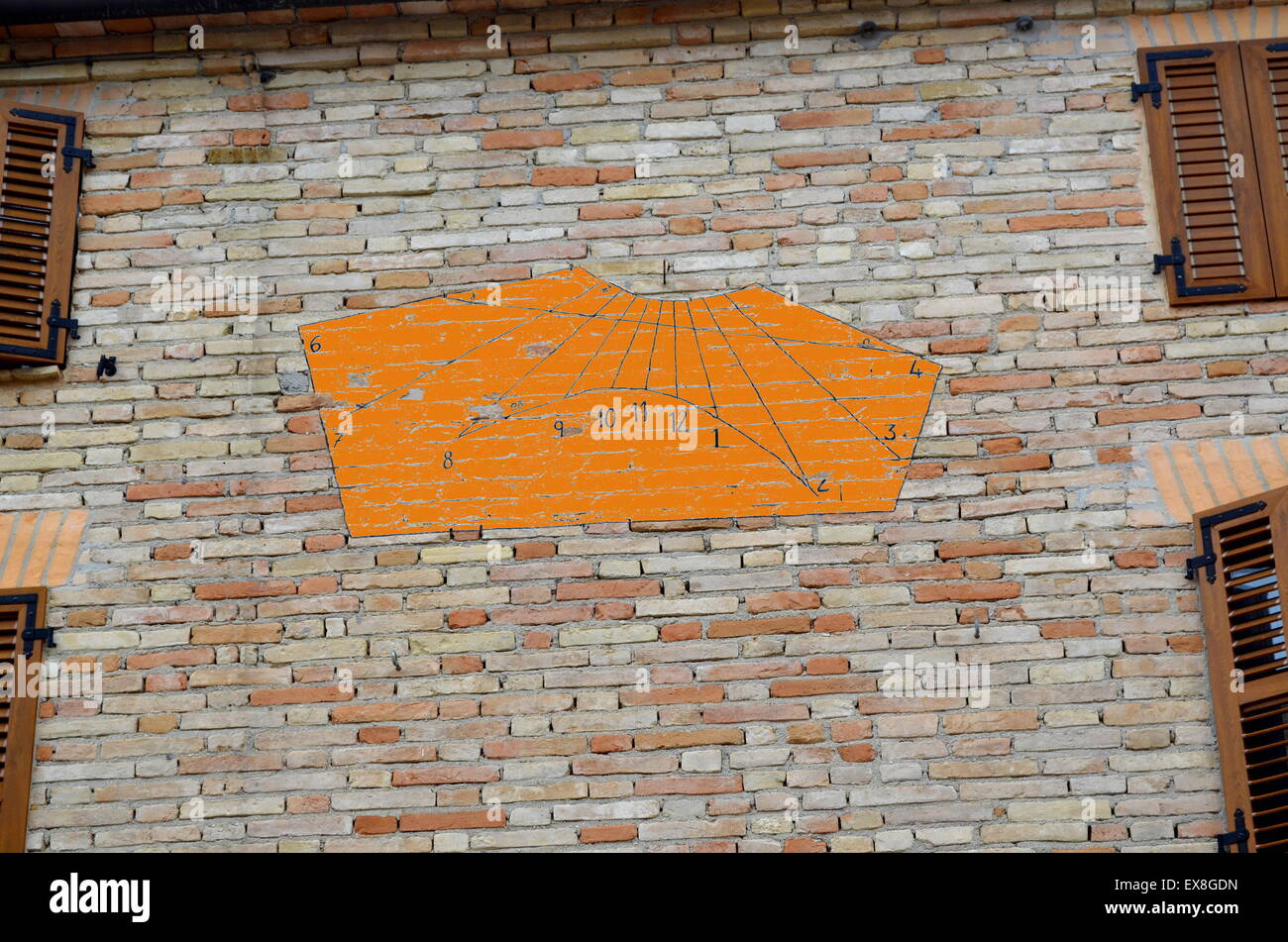 Orange sundial on a house wall Stock Photo - Alamy