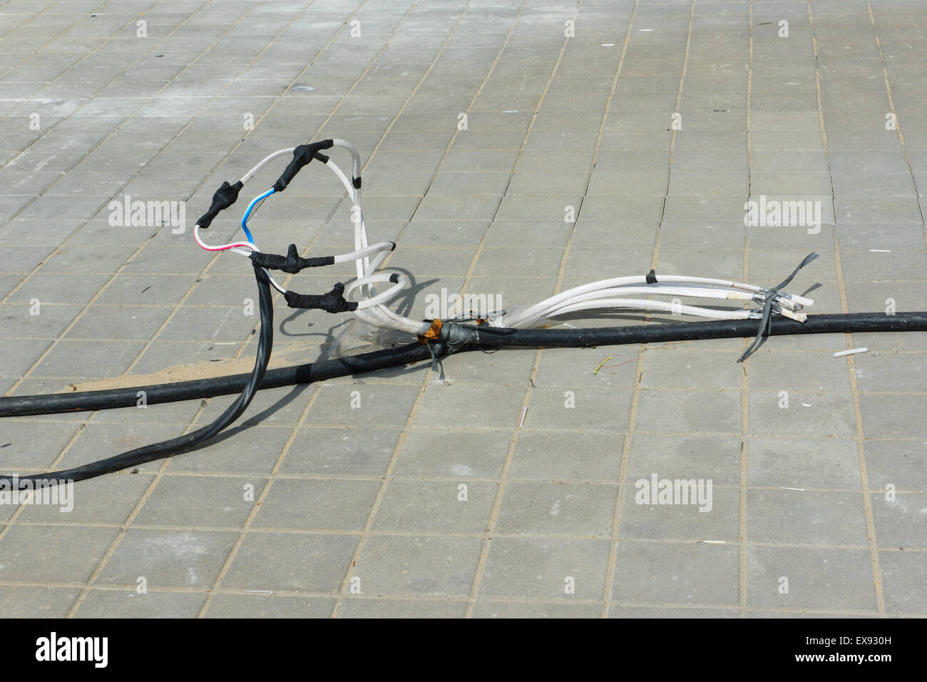 the powerful electric cable in isolation lies on asphalt Stock Photo ...