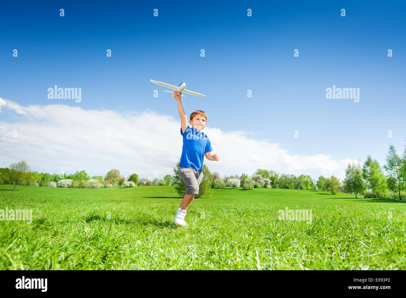 Happy boy holding airplane toy during running Stock Photo - Alamy