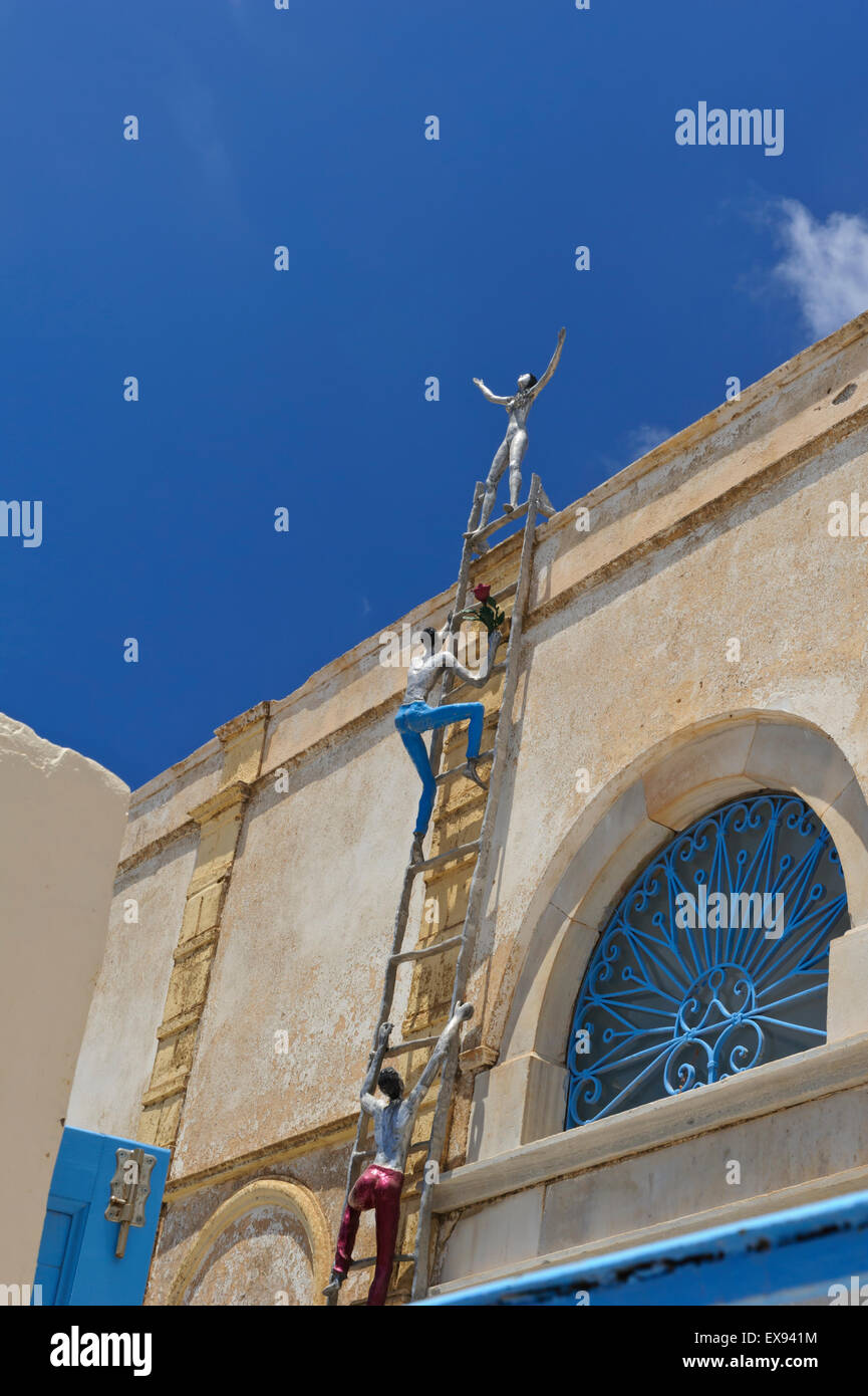 A sculpture of two male figures climbing a ladder outside a gallery in ...