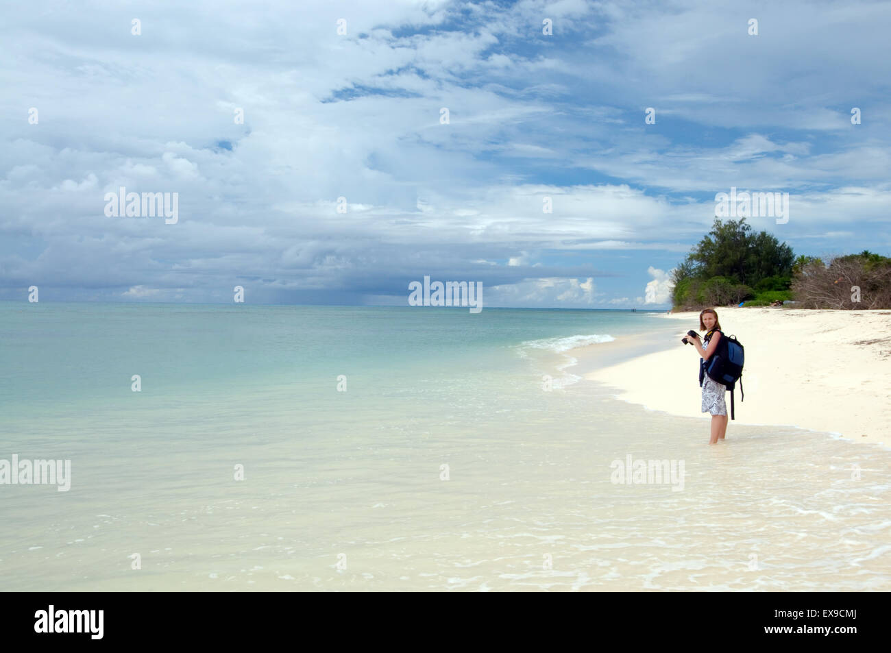 Young woman walking along the sandy shores of the Indian Ocean, Denis ...