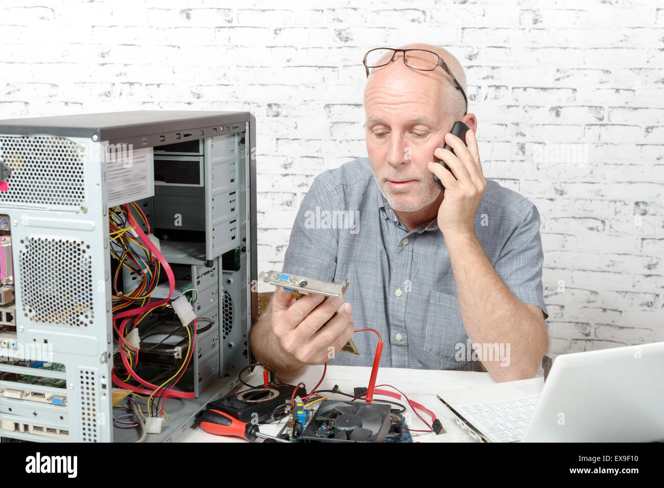 a technician repairing a computer and phone to the customer Stock Photo ...