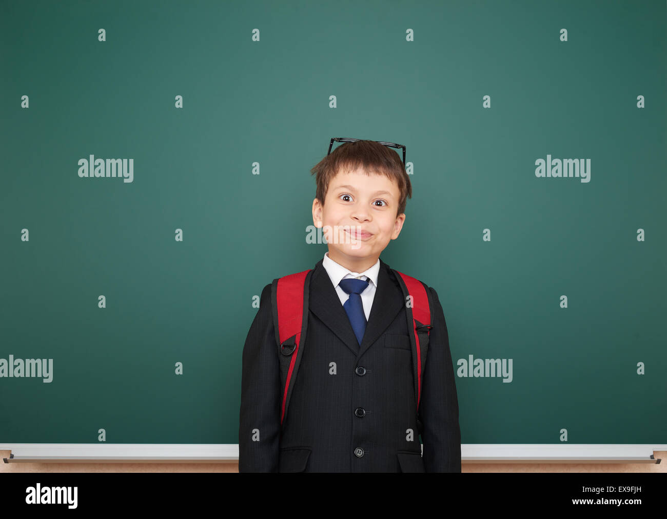 Schoolboy with backpack on school board background Stock Photo - Alamy