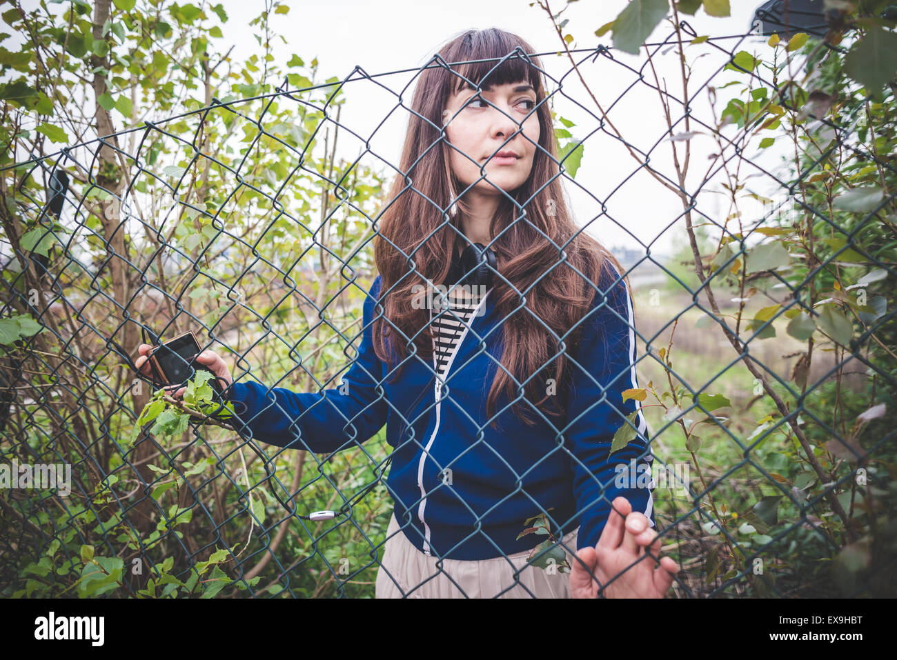 beautiful woman behind a grid in a desolate lurban landscape Stock ...
