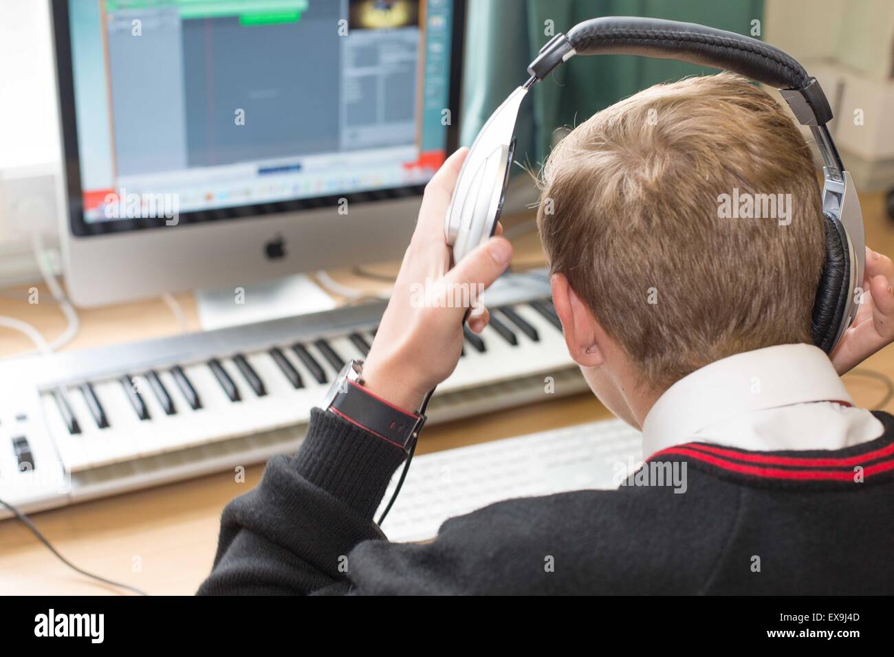 school students in uniform, utilising music software and equipment in ...