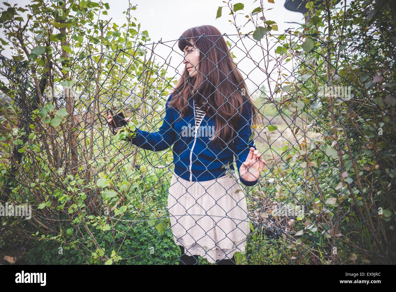 beautiful woman behind a grid in a desolate lurban landscape Stock ...