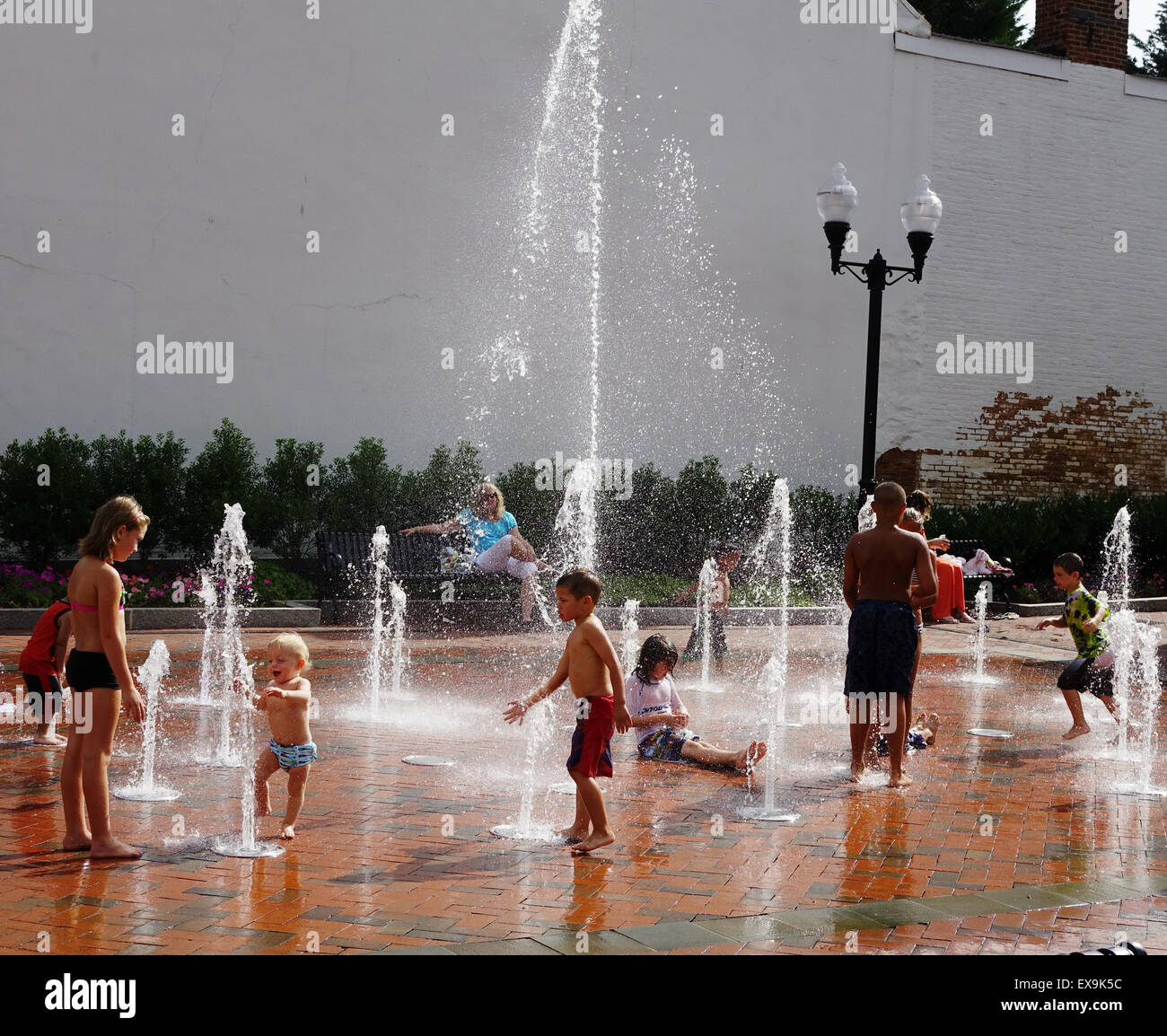 Children enjoying an outdoor fountain on a hot summer day in Old Town ...