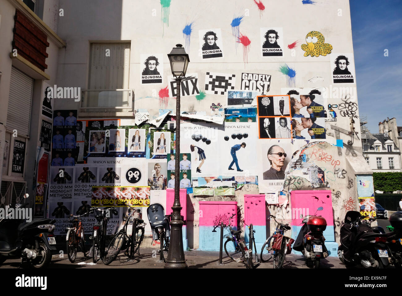 Street art mixed with promotional fashion posters on wall in Paris ...