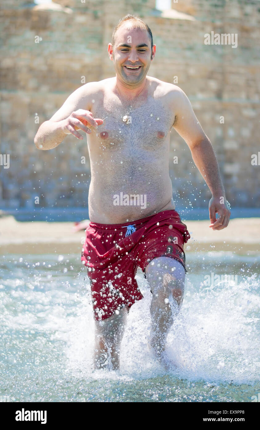 Happy man running into the sea water Stock Photo - Alamy