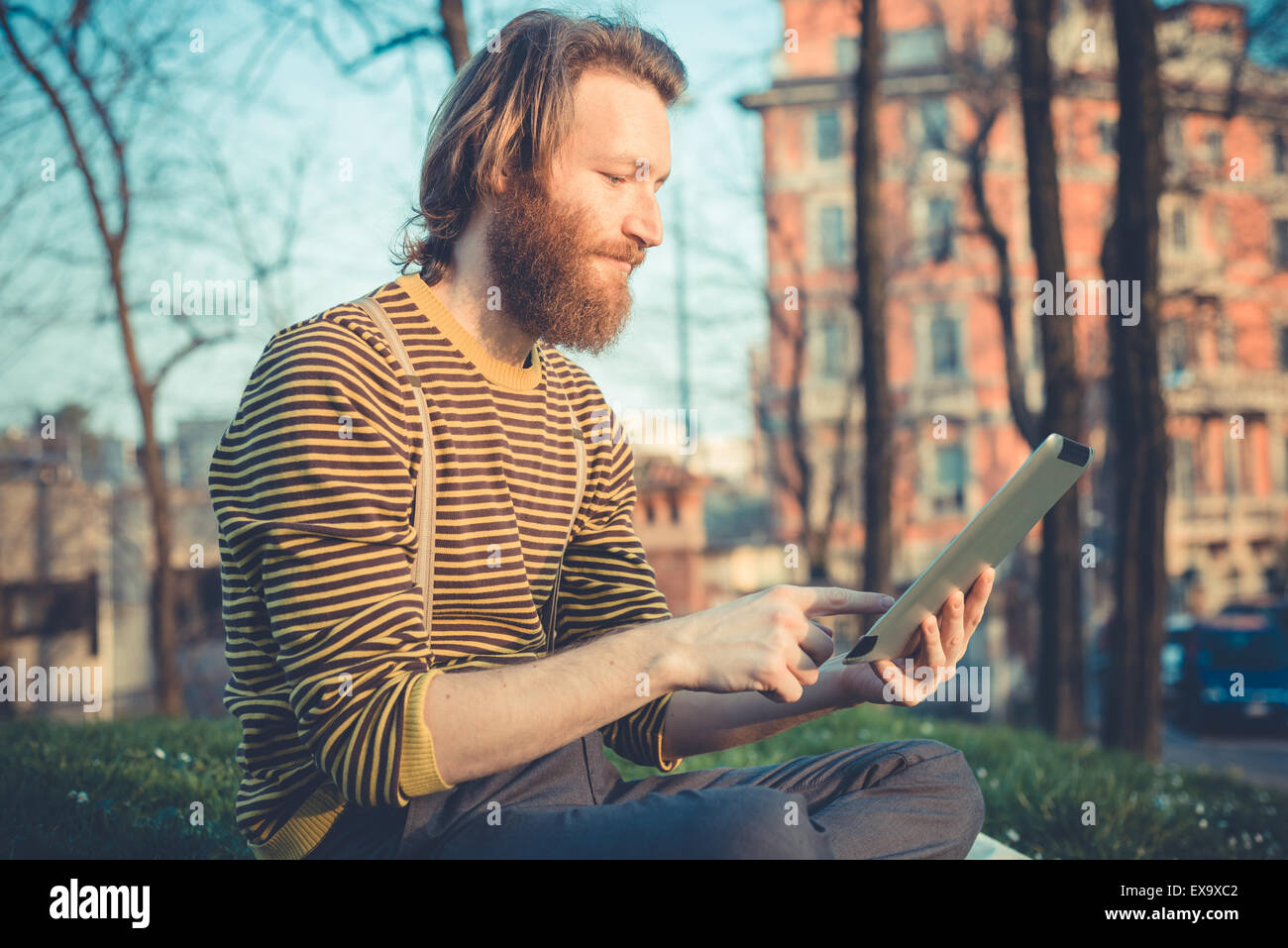young bearded stylish handsome hipster man using tablet outdoors Stock ...