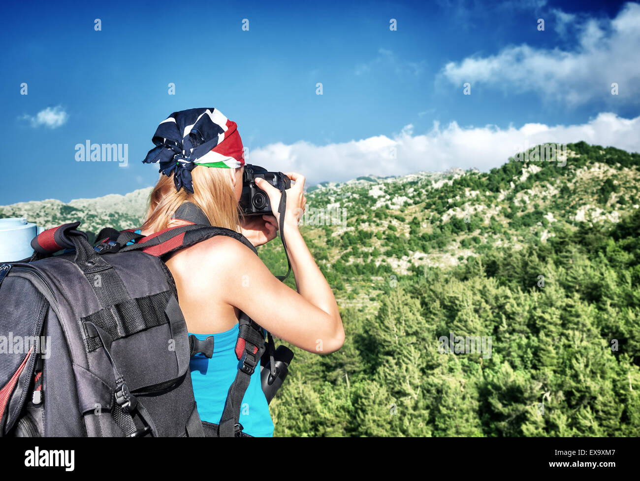 Young woman photographing beautiful mountains landscape, active ...