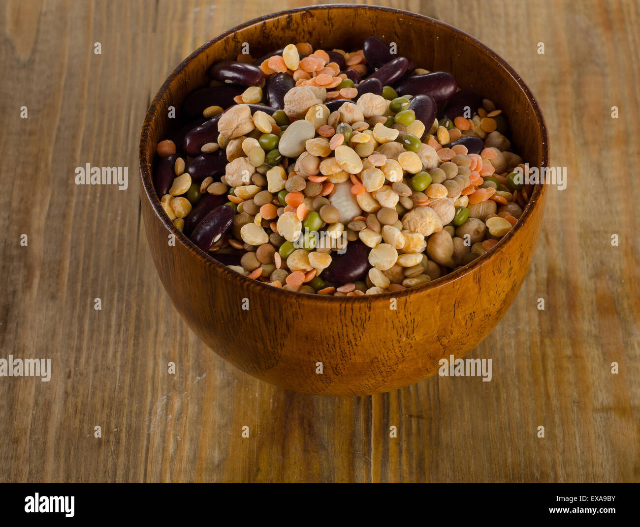 Multicolored mixed dried beans and lentils on a rustic wooden table ...