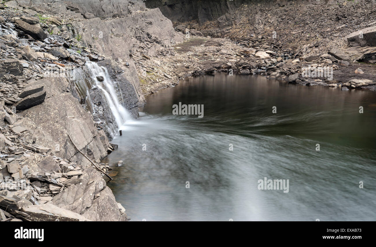 Landscape image of waterfall flowing into old abandoned quarry Stock ...