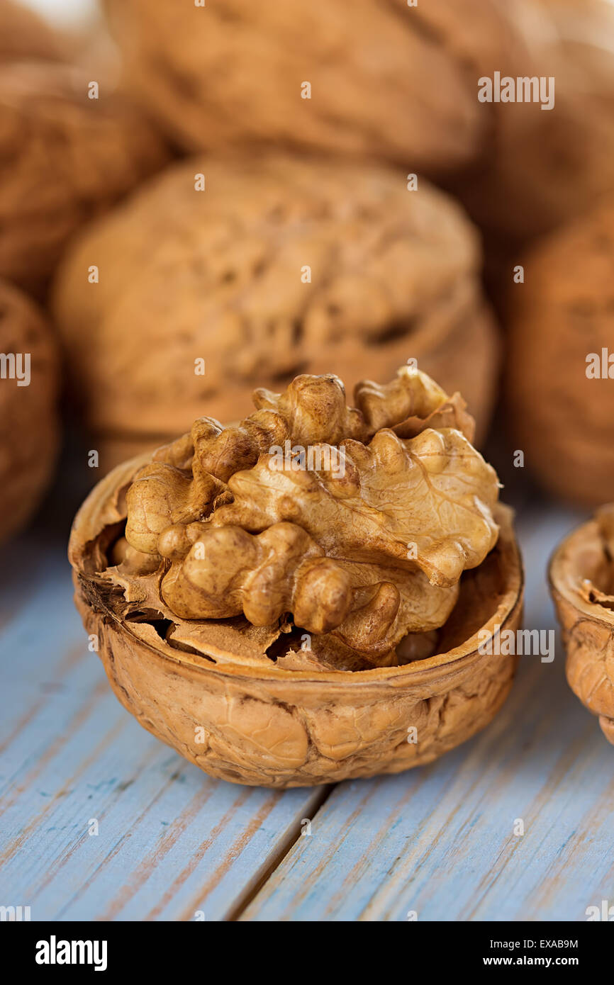Half walnut kernel and whole walnuts on a wooden background closeup ...