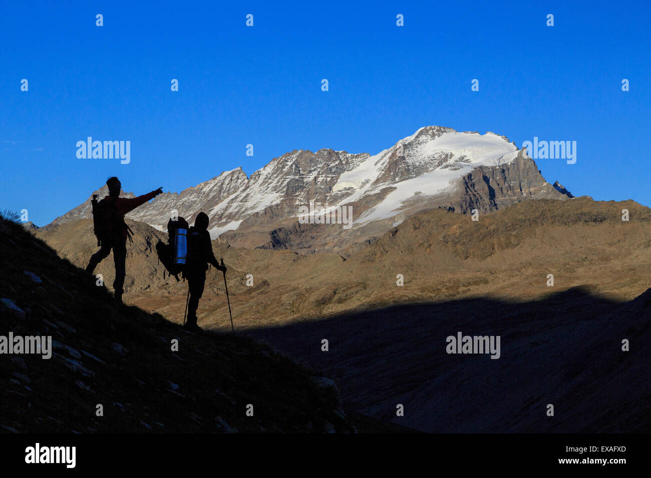 Hikers admire the view of Alpi Graie (Graian Alps) landscape, Gran ...